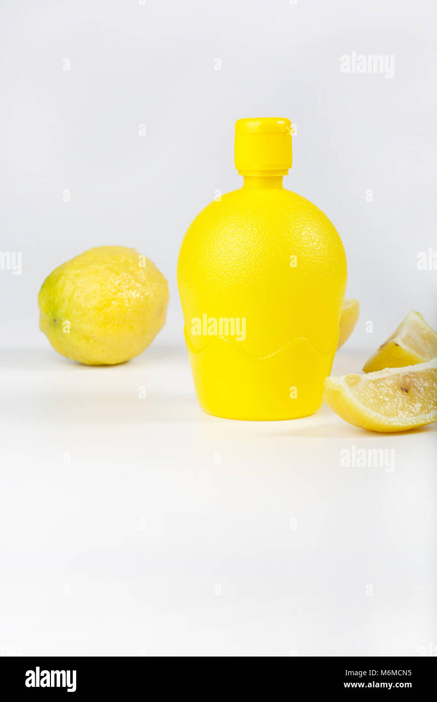 Liquid citric acid in a plastic bottle and pieces of fresh lemon ...