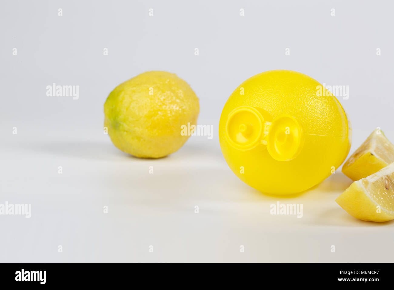 Liquid citric acid in a plastic bottle and pieces of fresh lemon ...