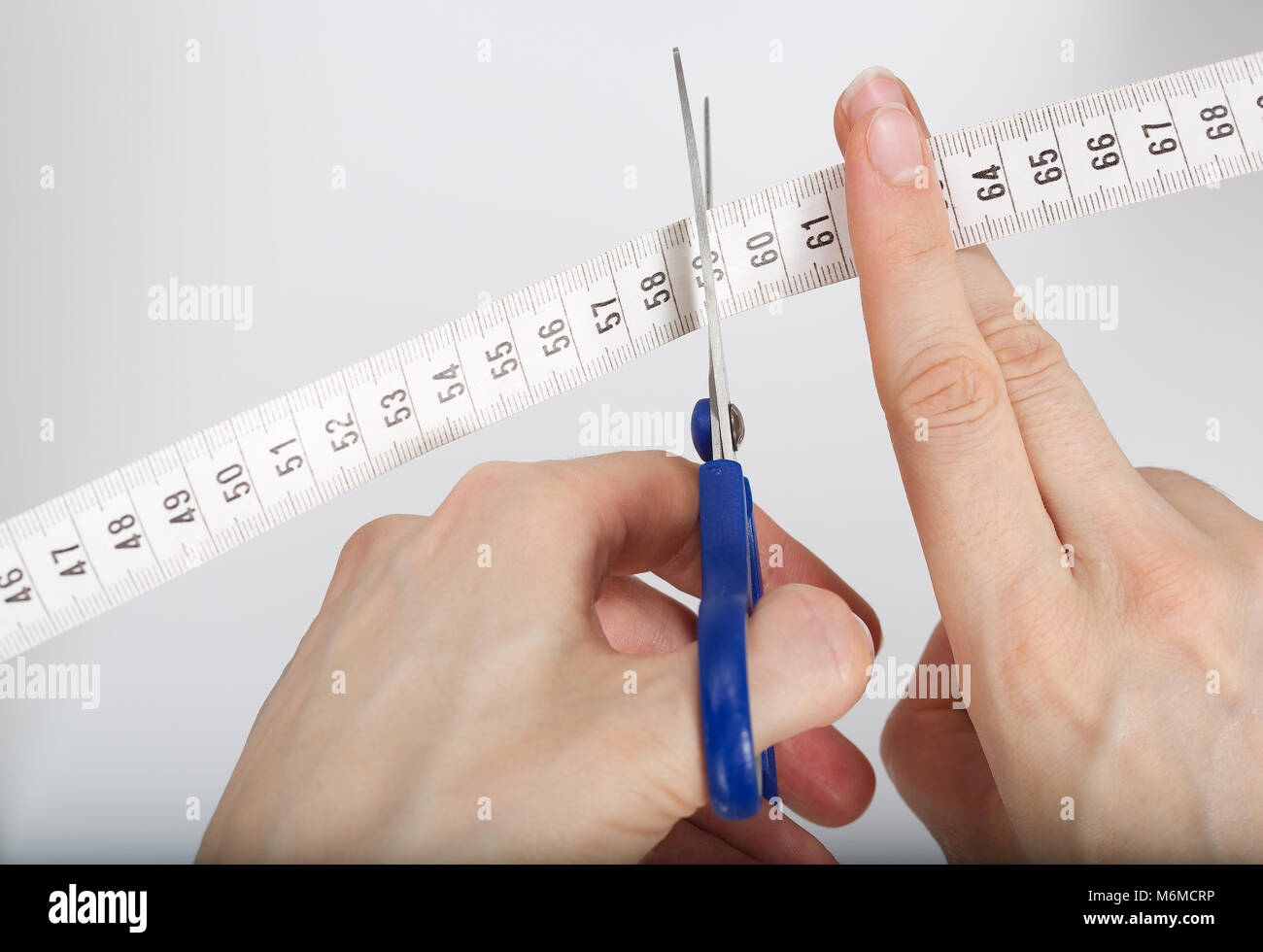 Scissors is cutting measuring band at number 60. Closeup Stock Photo ...