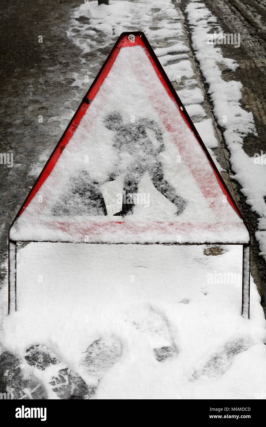 A Men At Work sign covered in snow Stock Photo - Alamy