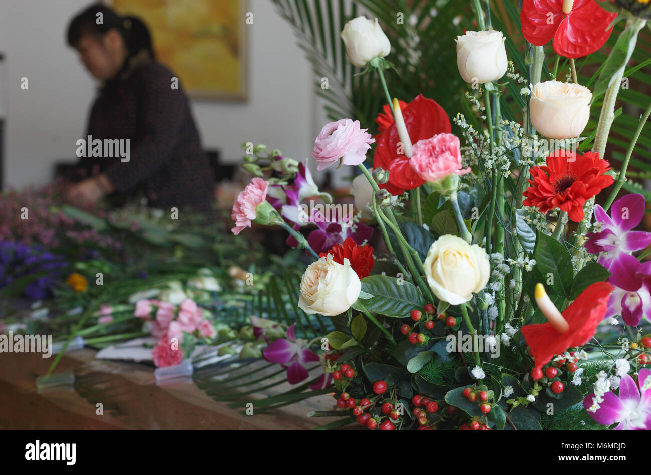 a woman is decorating flowers,Flower arranging scene Stock Photo - Alamy