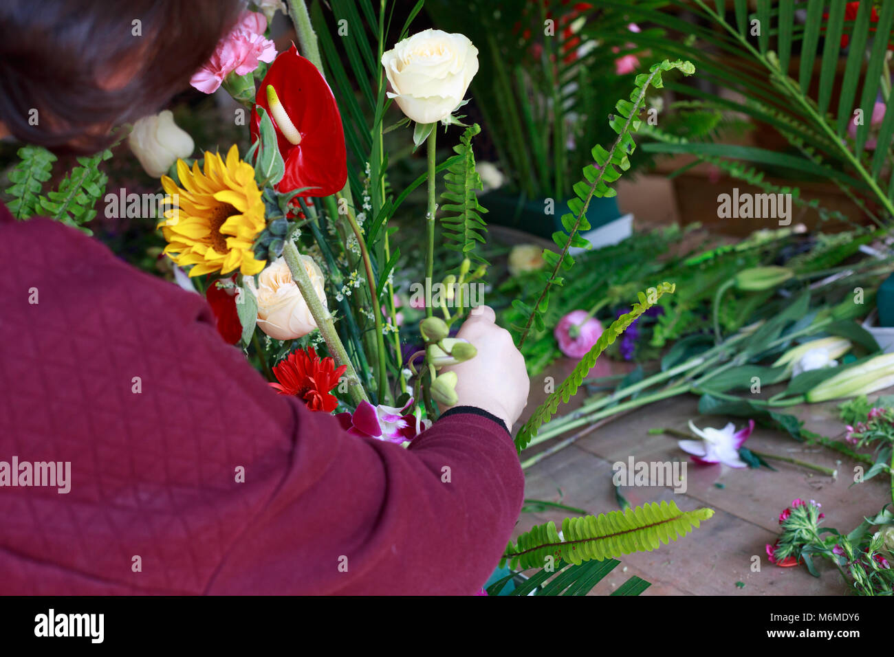 a woman is decorating flowers,Flower arranging scene Stock Photo - Alamy