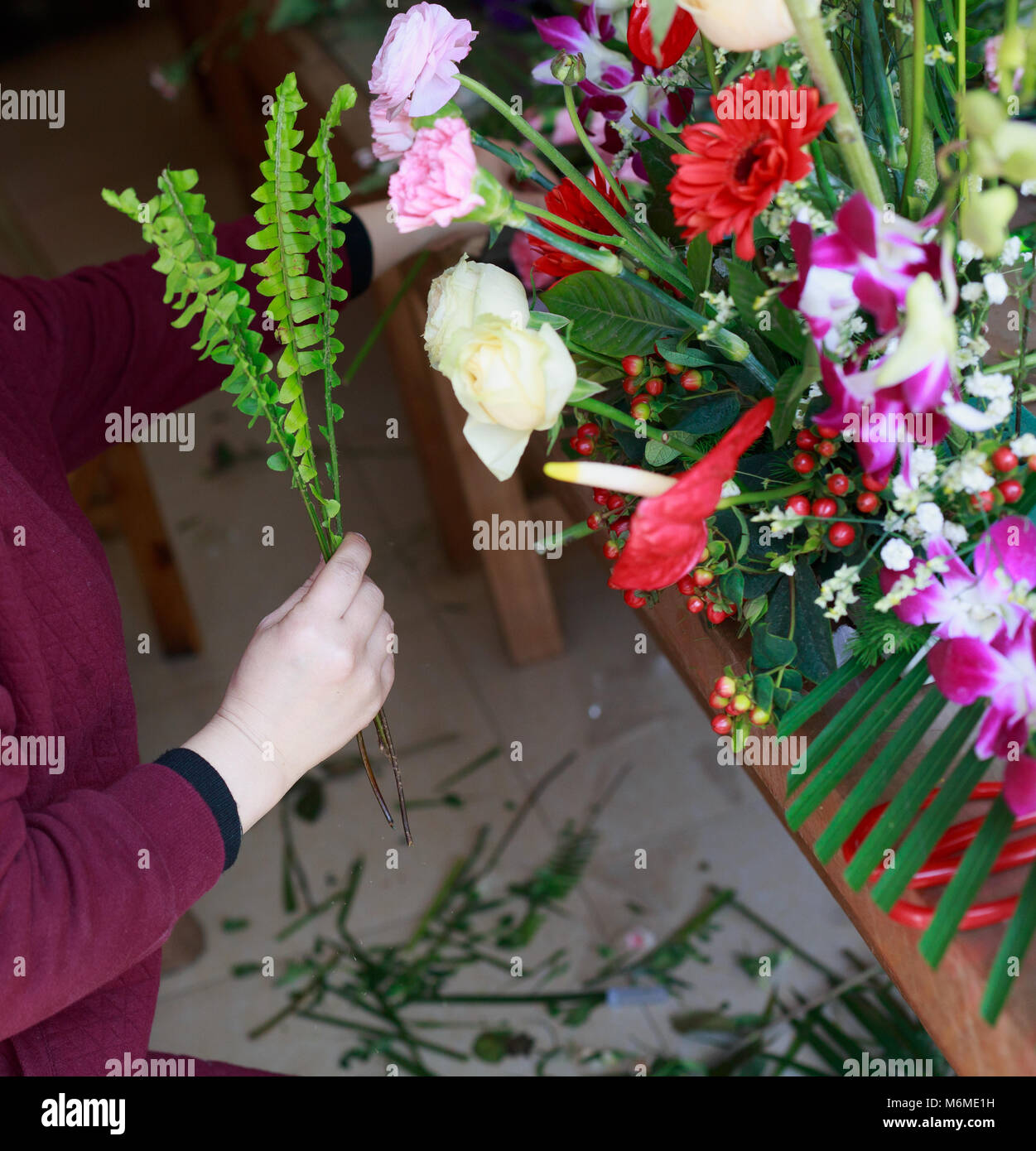a woman is decorating flowers,Flower arranging scene Stock Photo - Alamy
