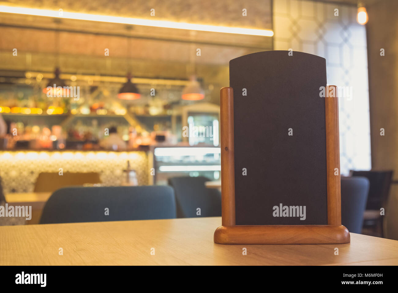 Blackboard menu with easel on wooden table with blur restaurant ...
