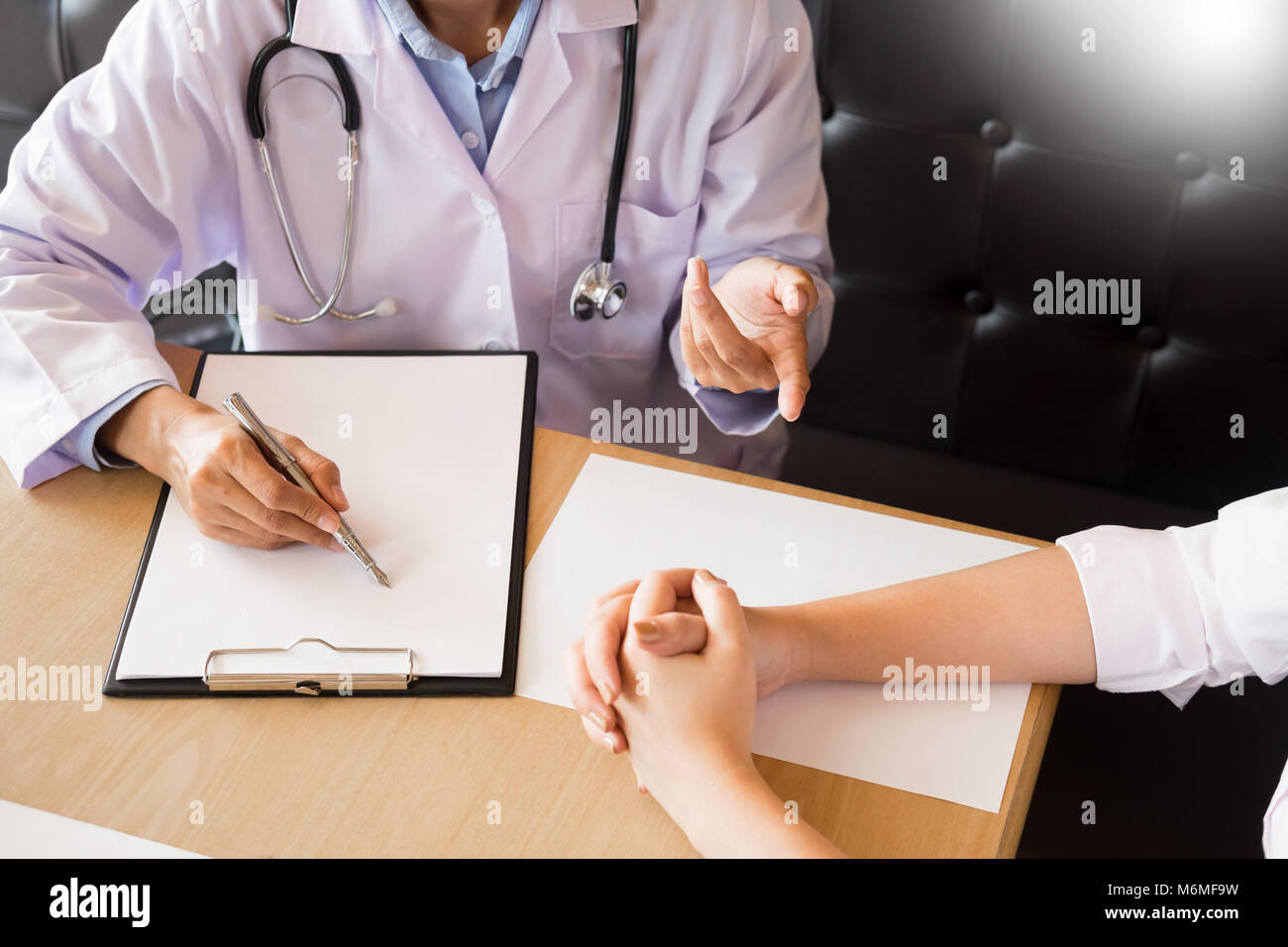 patient listening intently to a male doctor explaining patient symptoms ...