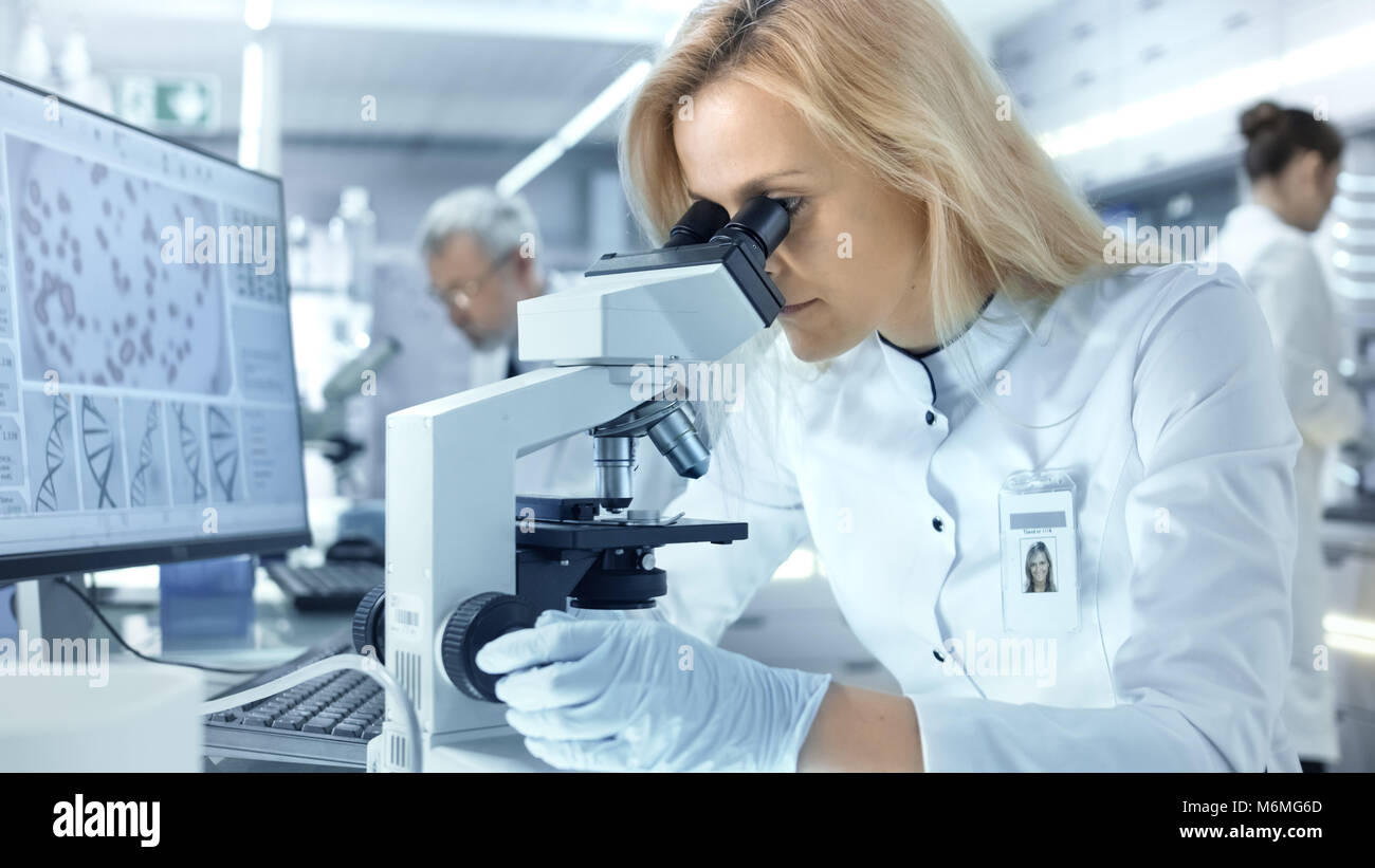 Female Research Scientist Looks at Biological Samples Under Microscope ...