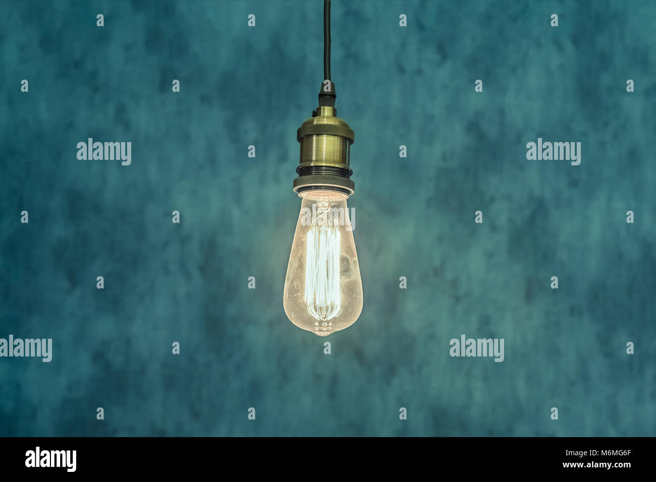 Decorative antique edison style light bulb against blue background ...