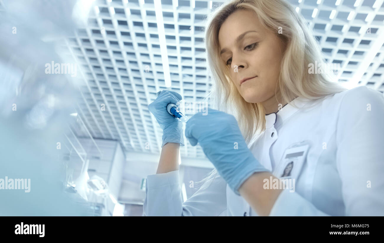 Low Angle Shot of Medical Research Scientist Uses Micropipette to Fill ...