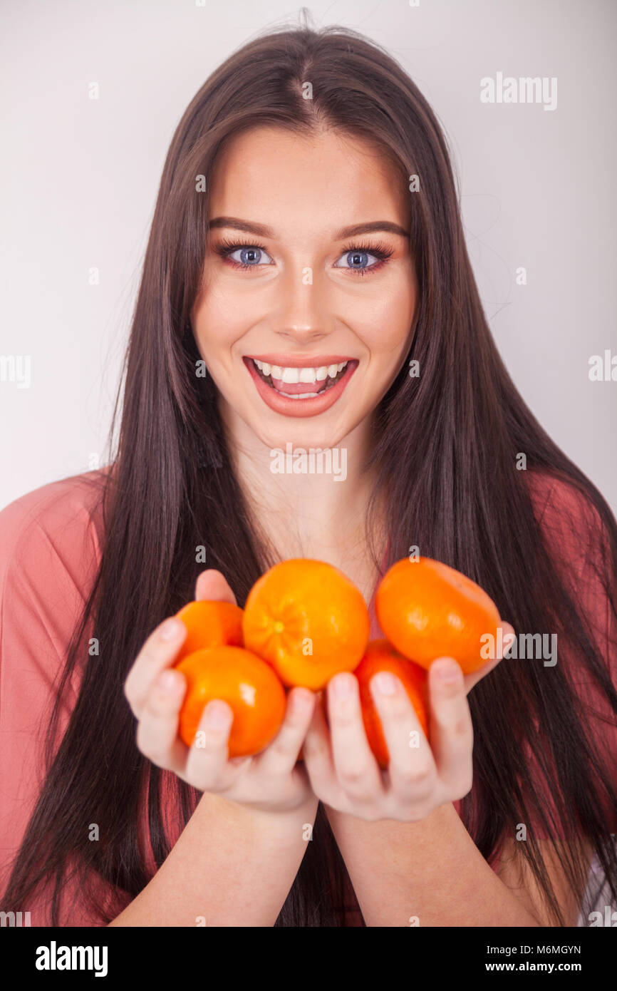 A pretty teenage girl with a handful of oranges Stock Photo - Alamy