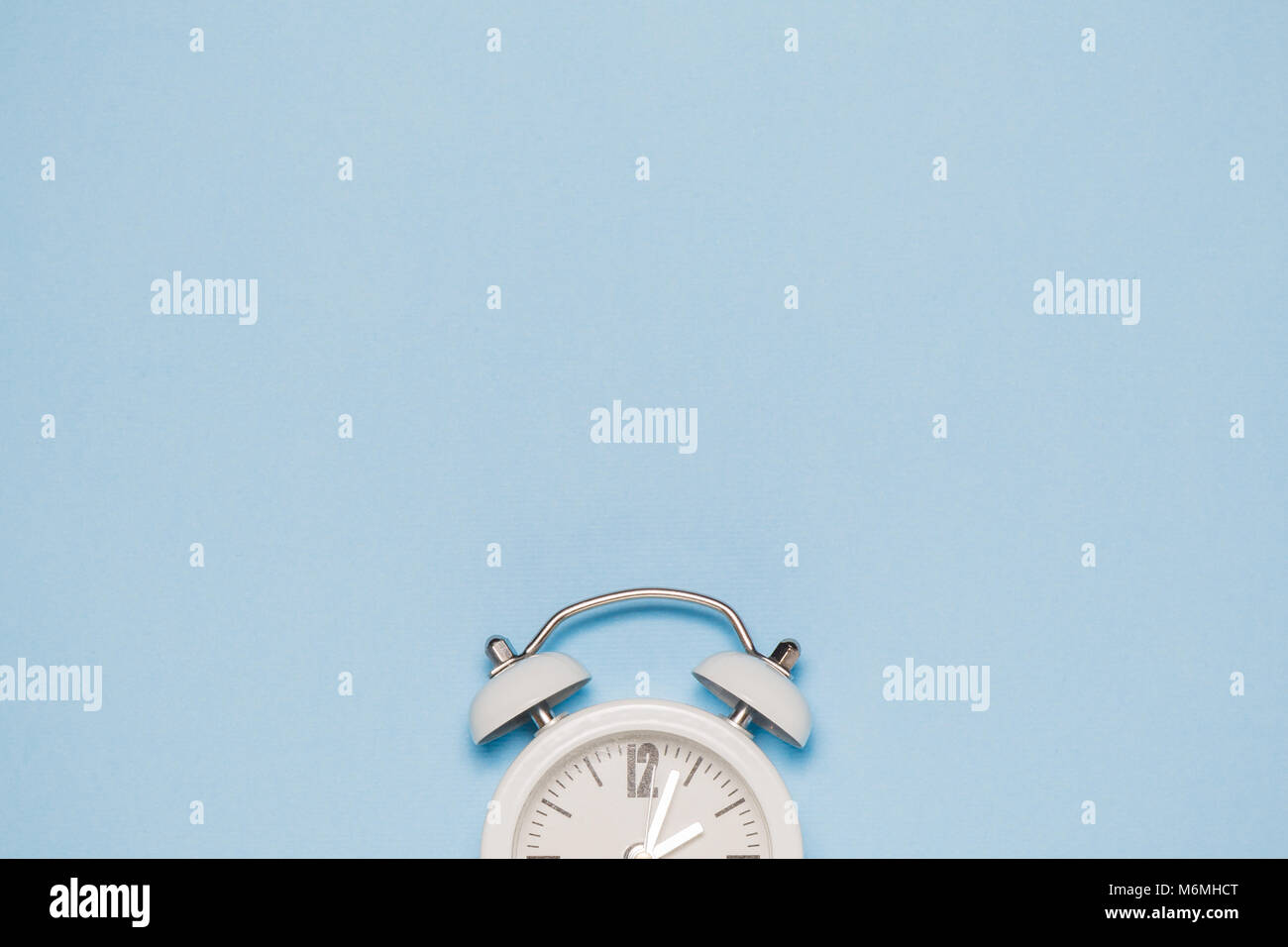 White clock on pastel blue background. Space for copy. Minimal concept ...