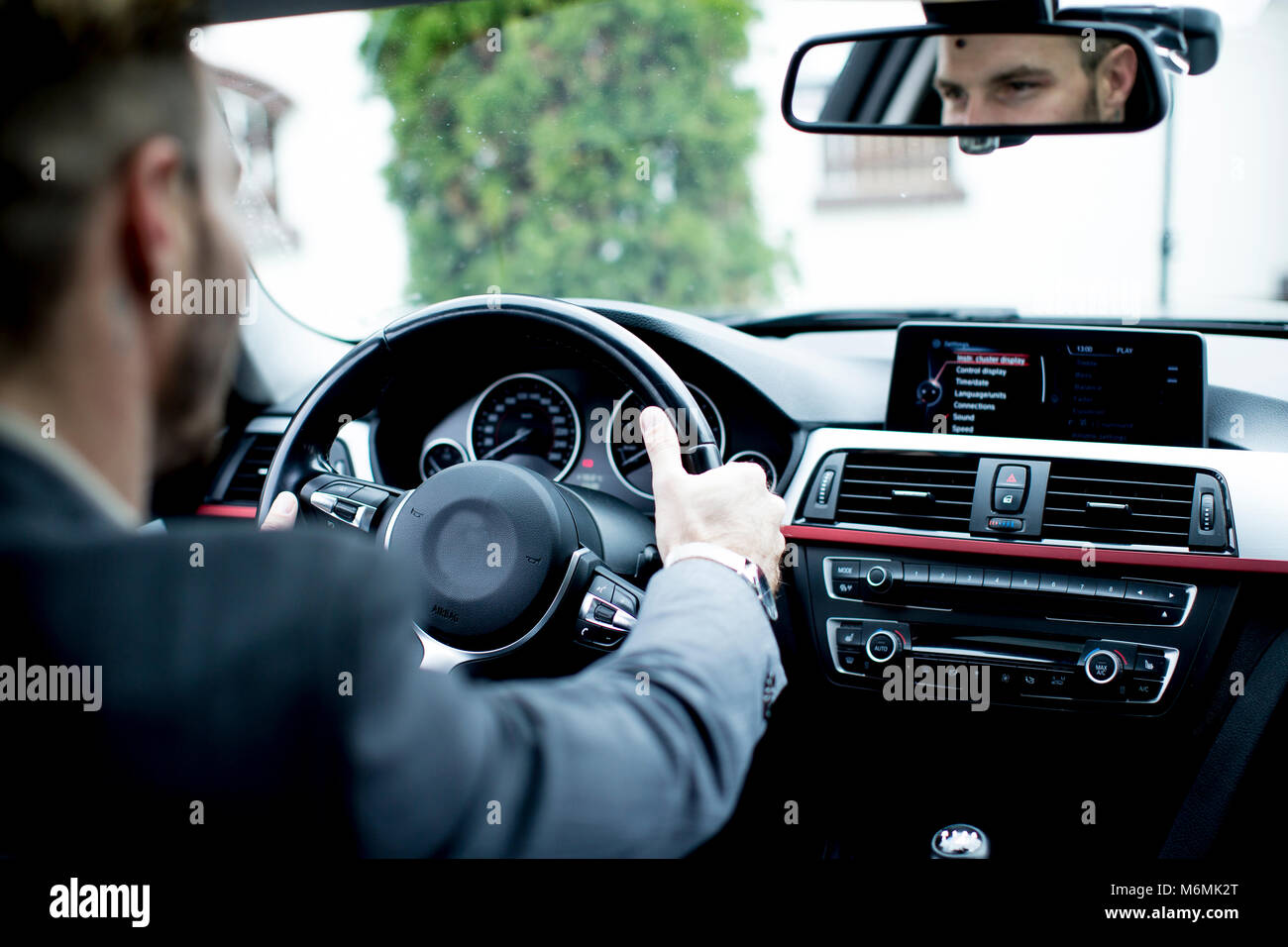 Back view of an handsome smiling business man driving his car Stock ...