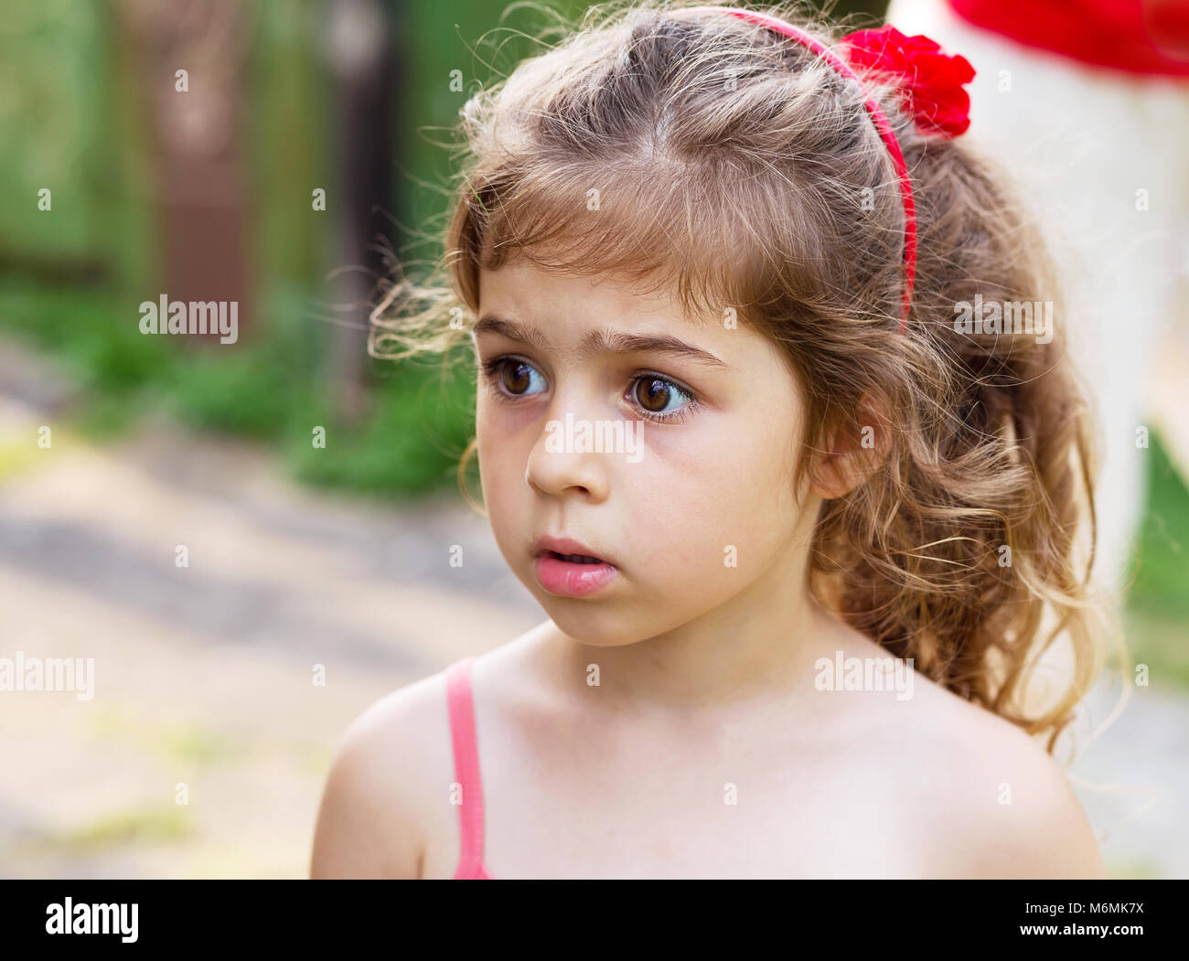 Portrait of beautiful little girl looking sad and afraid outdoors Stock ...