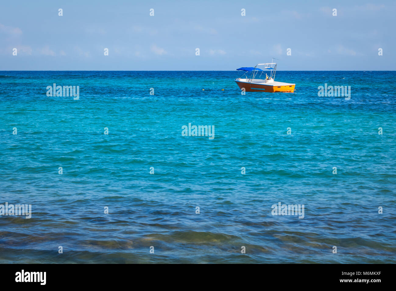Small orange fishing boat, tourist boat in open water. Tropical ...