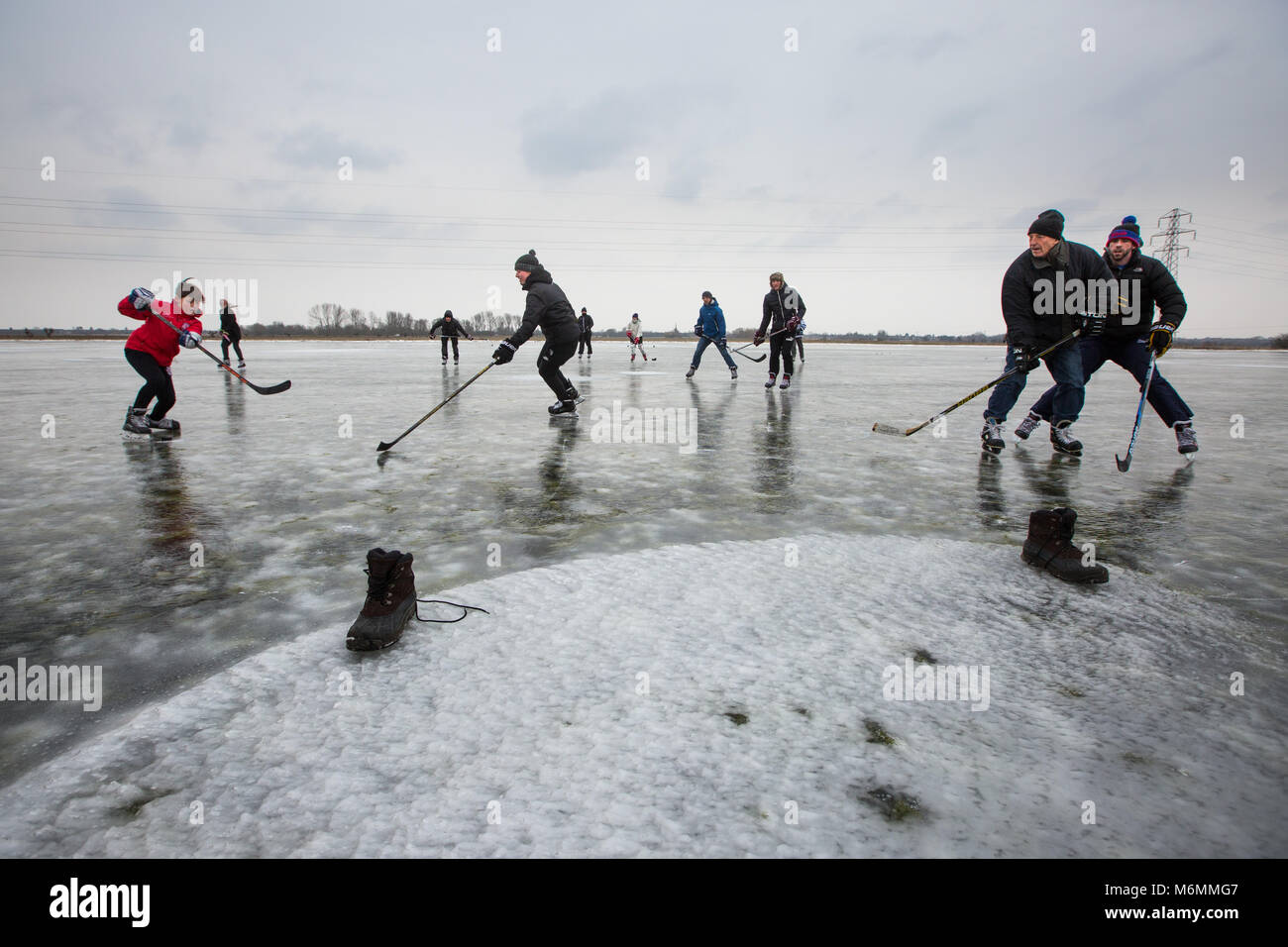 People playing ice hockey and skating on the Cambridgeshire Fens near ...