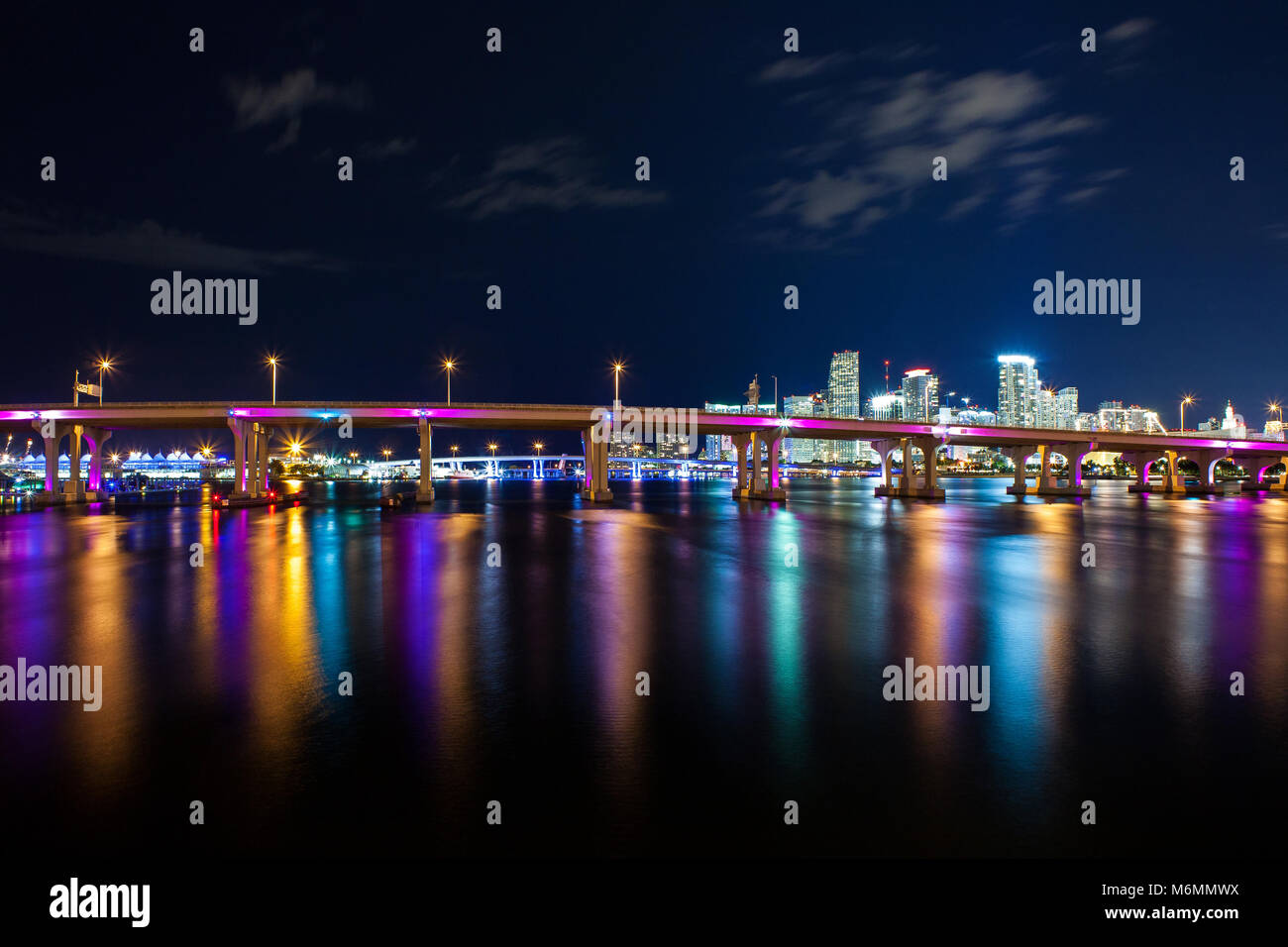 View of MacArthur Causeway bridge in Miami at night over water. View ...