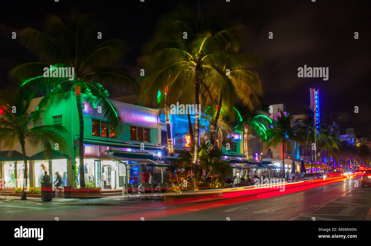 Ocean Drive in Miami at night with vibrant street colours. Cars passing ...
