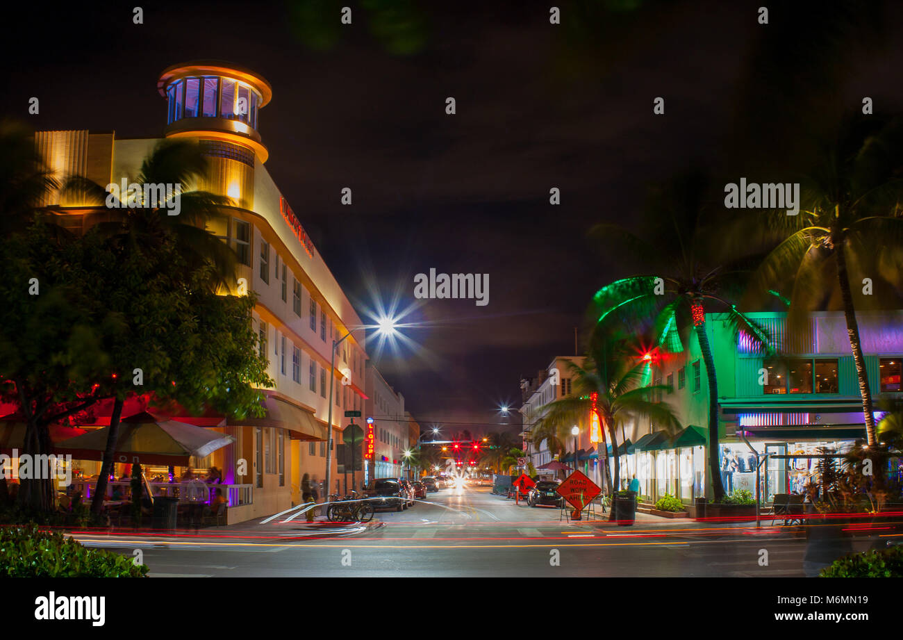 Ocean Drive in Miami at night with vibrant street colours. Cars passing ...
