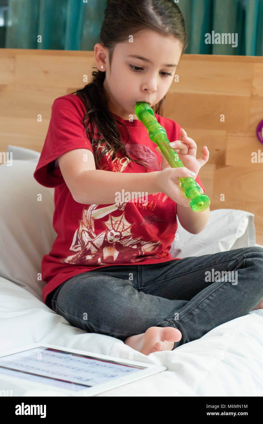Child learning to play flute with the help of online Videos Stock Photo ...