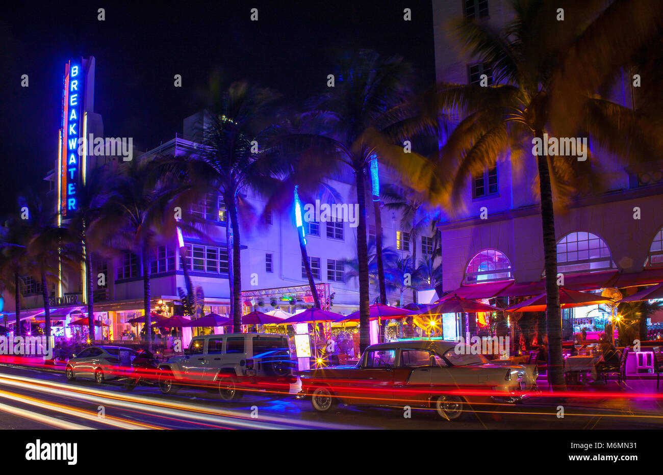 Ocean Drive in Miami at night with vibrant street colours. Cars passing ...