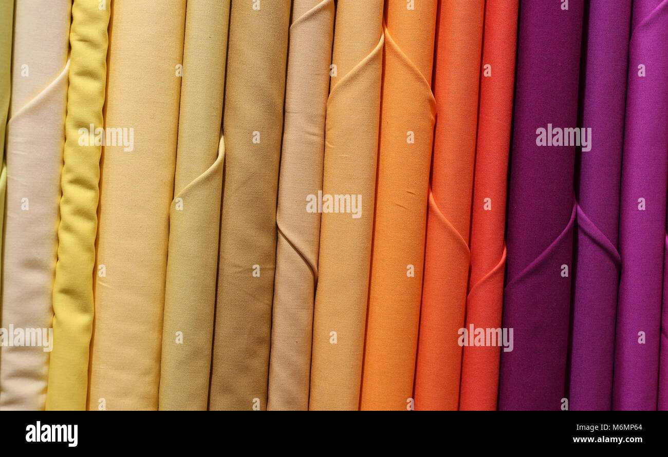 colorful background of fabrics of many colors in the seamstress's shop ...
