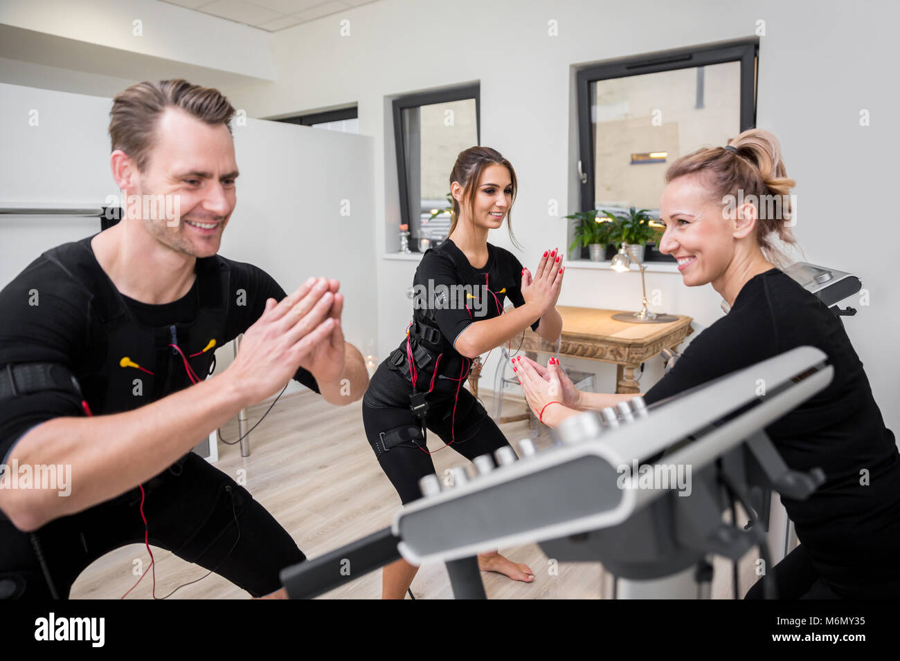 Portrait of personal coach showing young people correct pose for ...