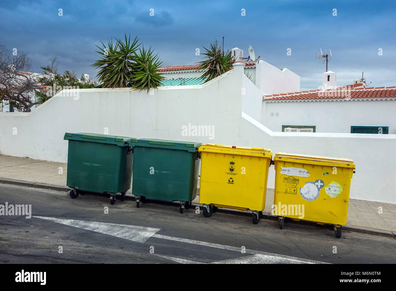 green and yellow waste bins on road side, by white walls, Tenerife ...