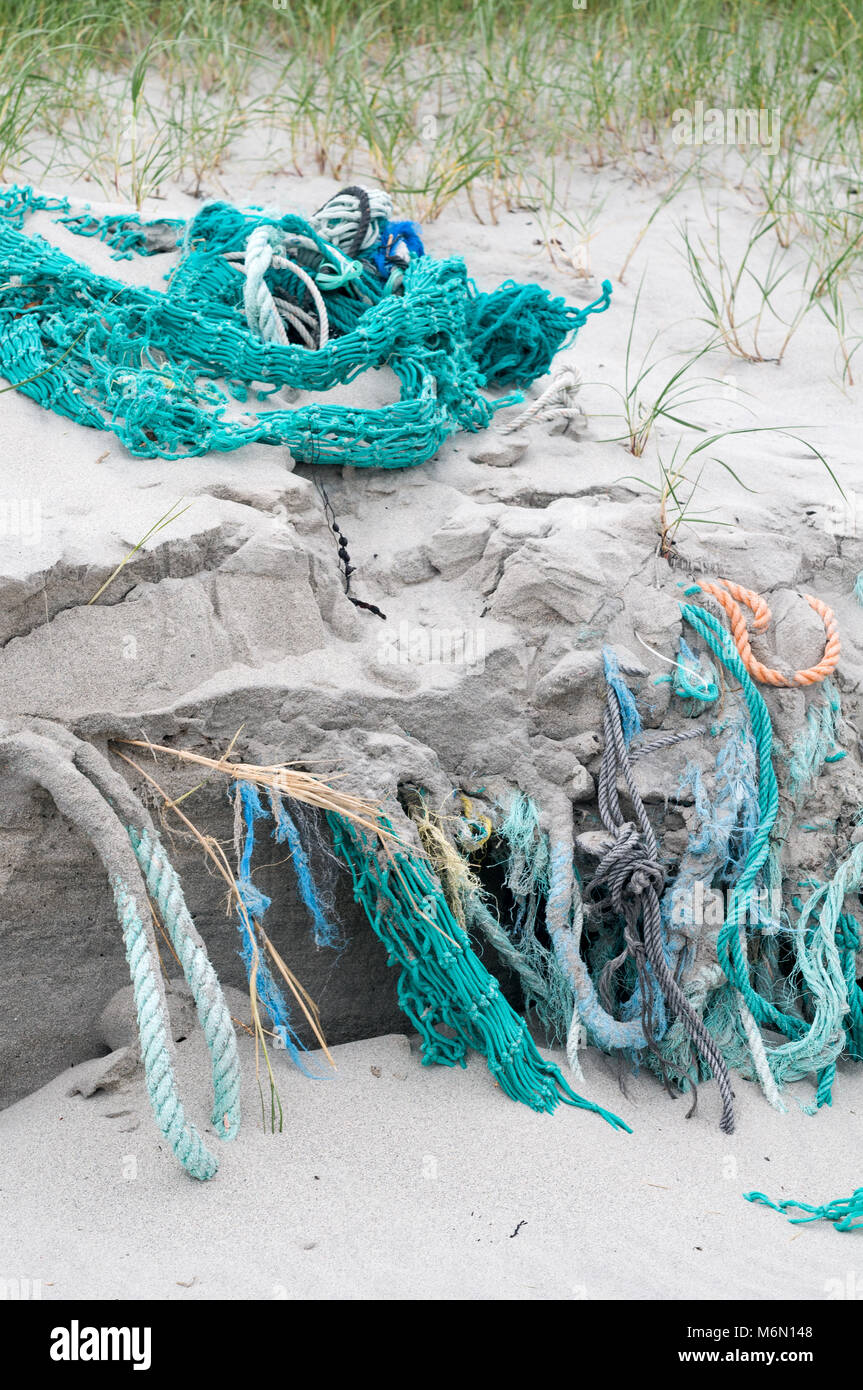 Fishing ropes and nets discarded and entangled in the beach and sand ...