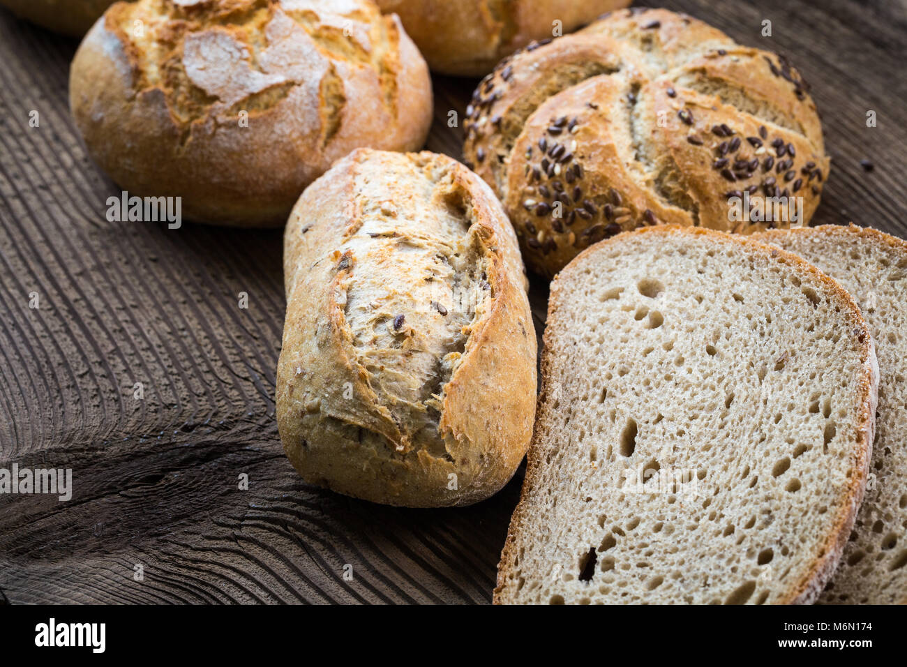 Different kinds of fresh bread on wooden table. Isolated assortment of ...