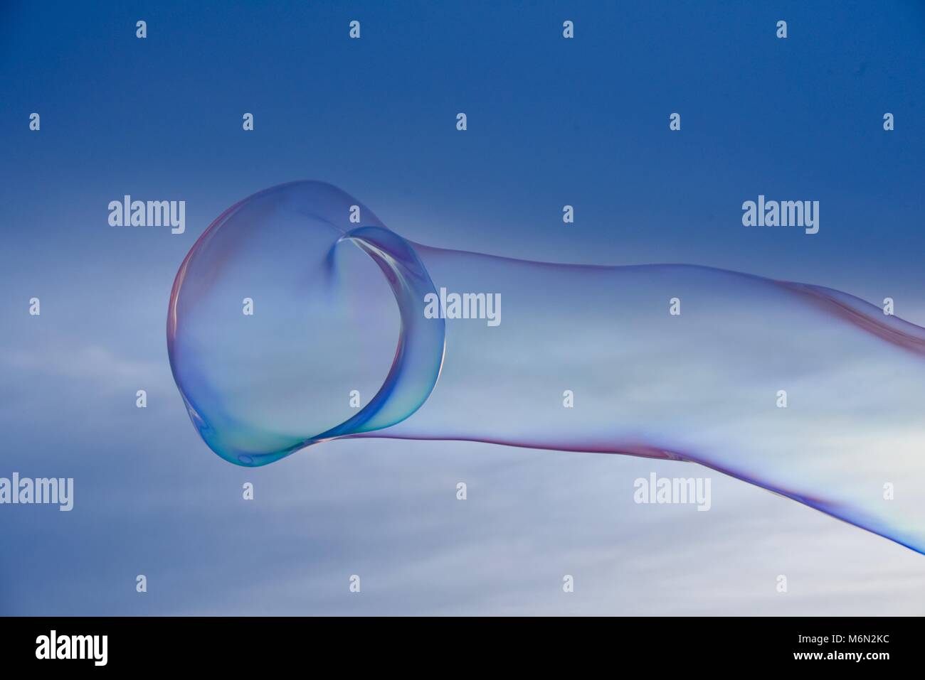 Oddly shaped, large, big soap bubbles floating in air at sunset ...