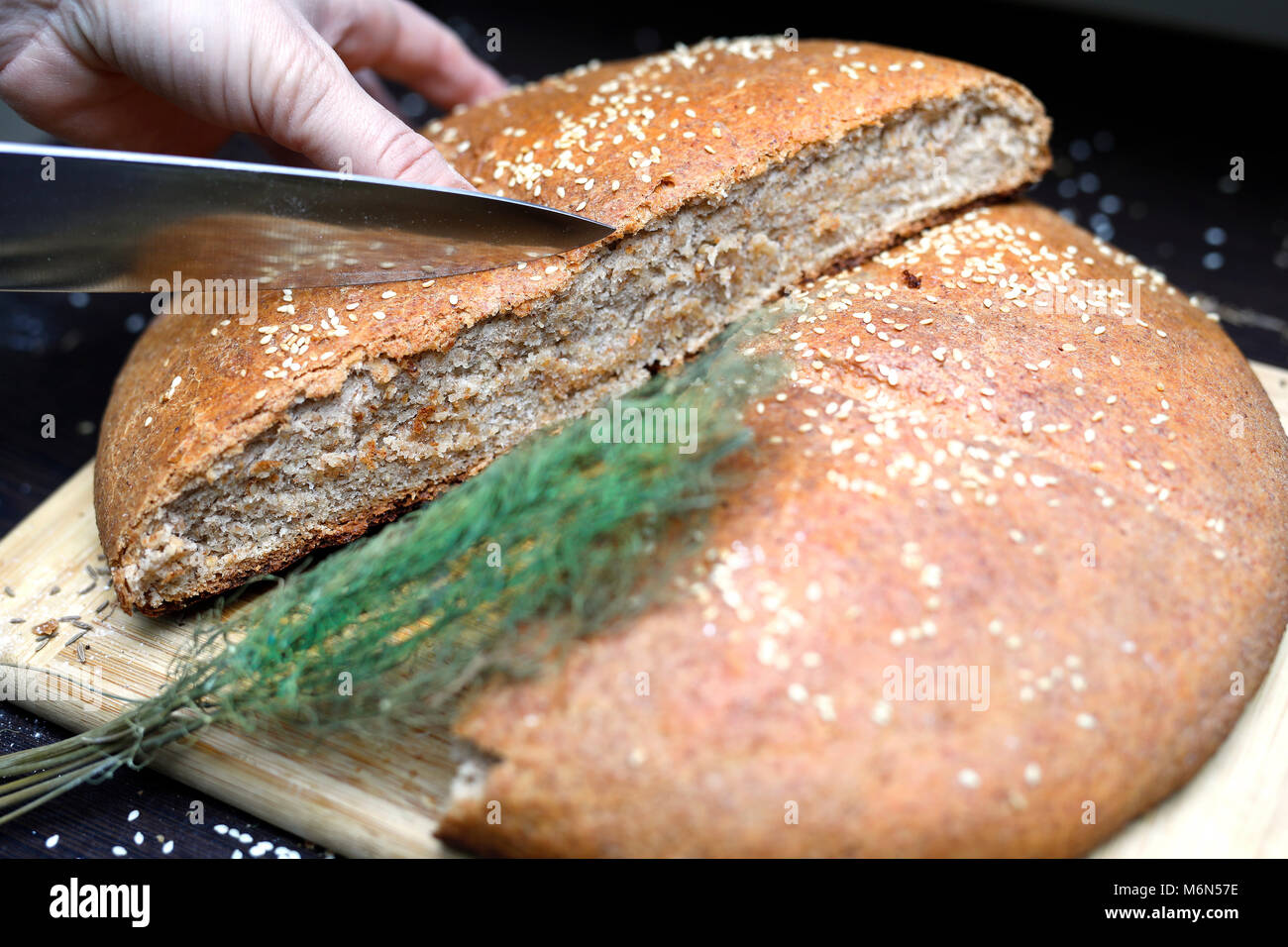 Cutting home made integral bread Stock Photo - Alamy