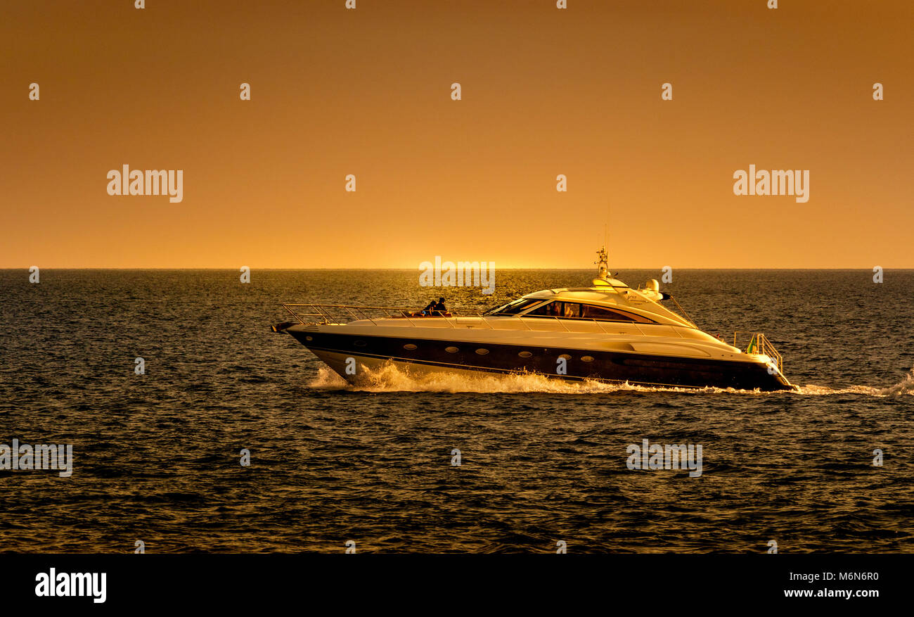 Speed boat motor cruiser at sunset Stock Photo - Alamy