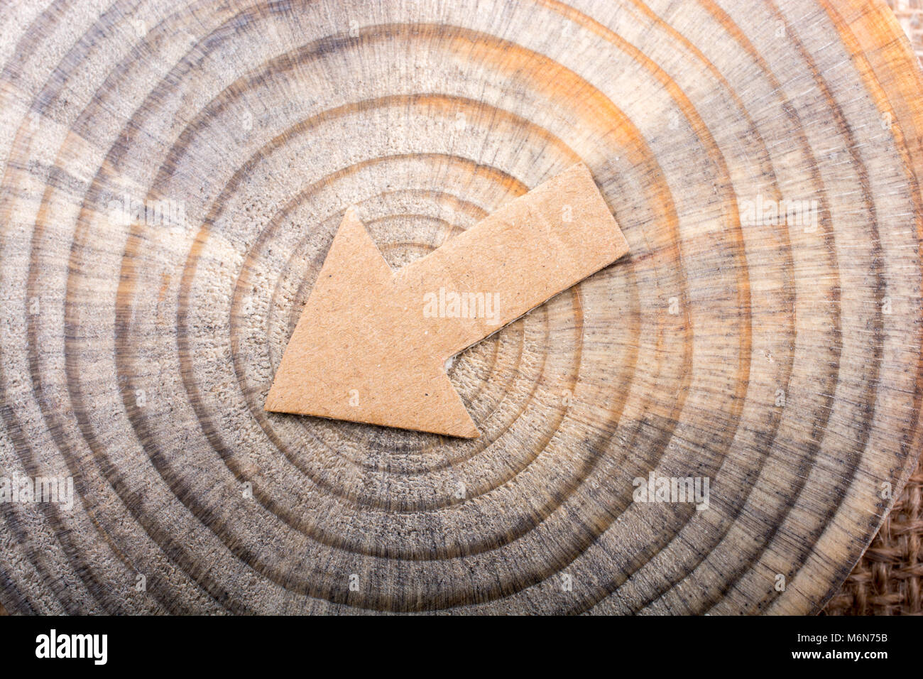 Arrow sign cut out of brown paper in view Stock Photo - Alamy