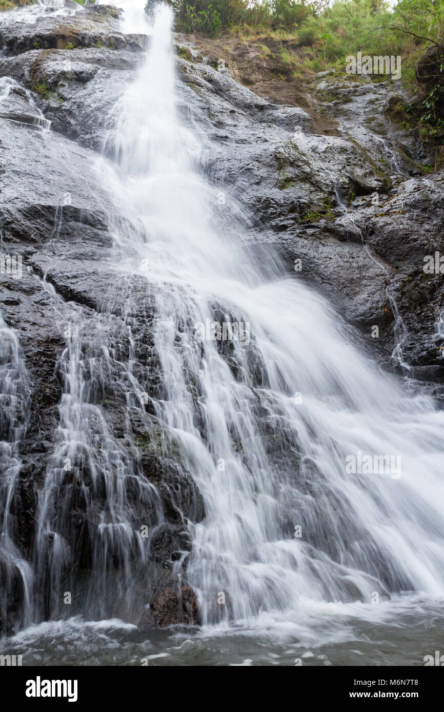 tall rock cliff with a waterfall running down it in tropical Costa Rica ...