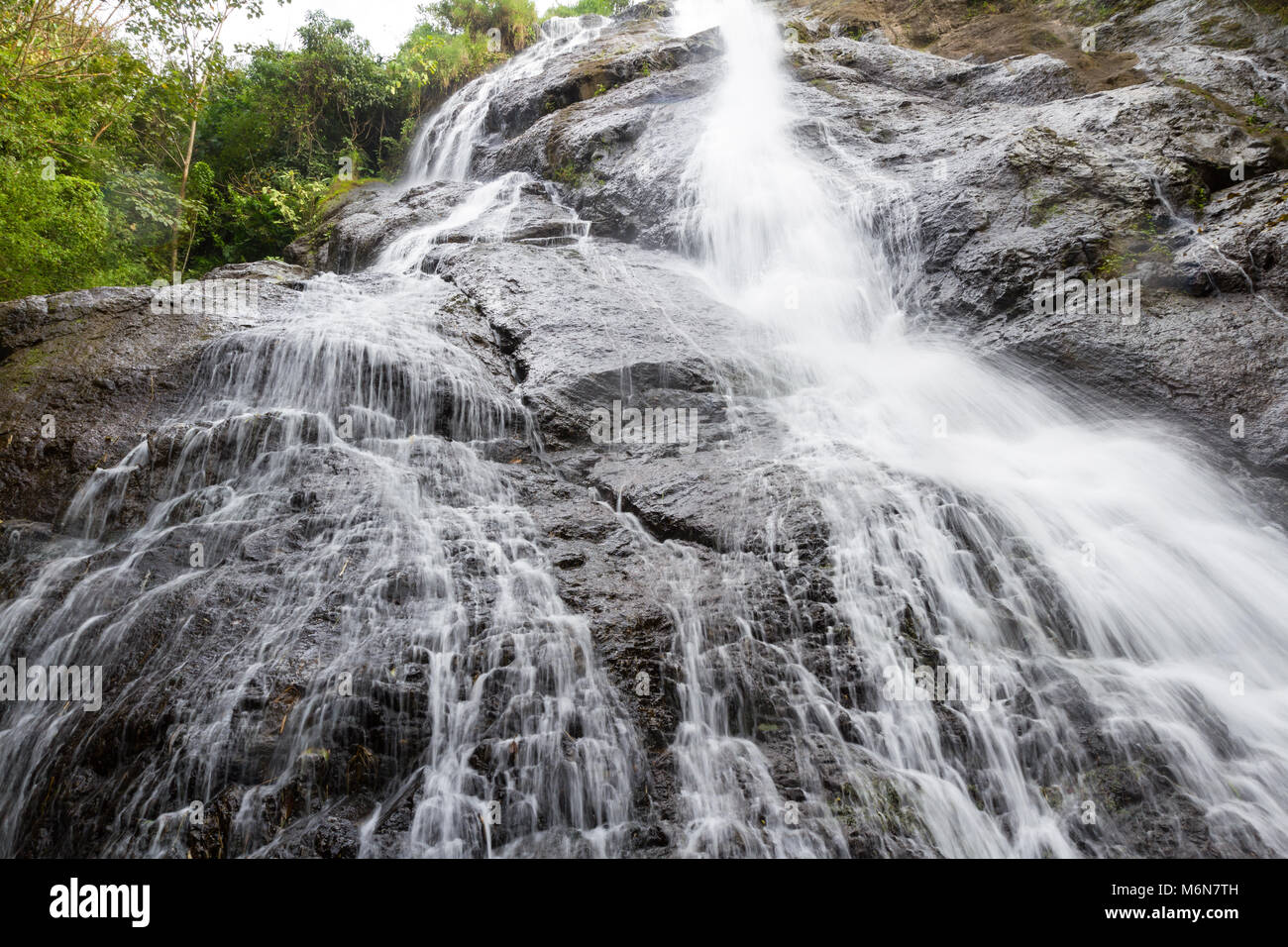 tall rock cliff with a waterfall running down it in tropical Costa Rica ...