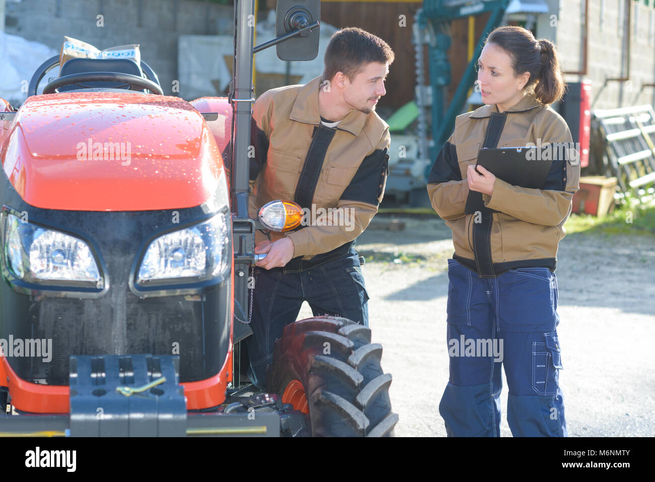 agricultural mechanics checking tractors condition before harvesting ...