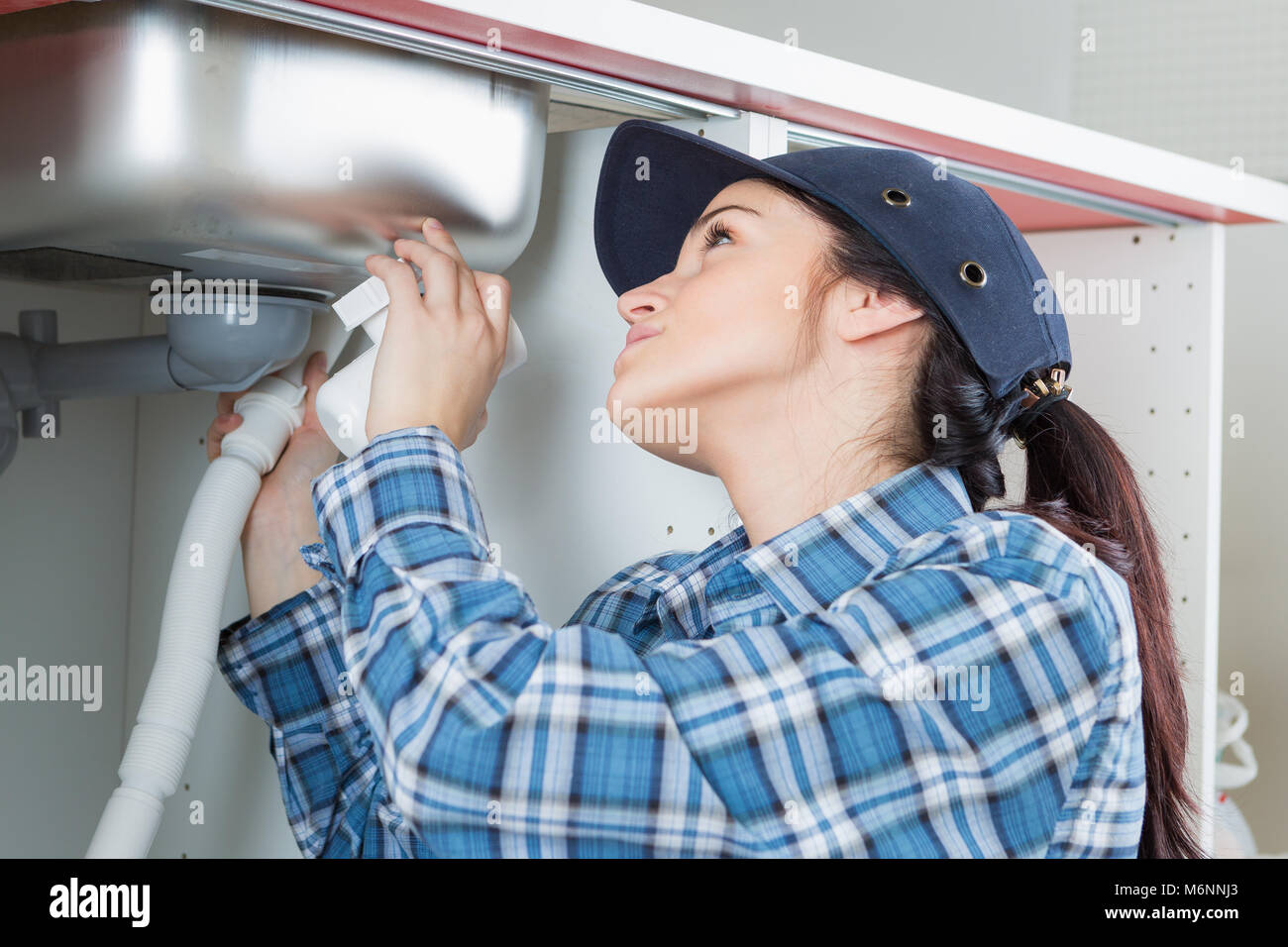 Female plumber fitting sink Stock Photo - Alamy