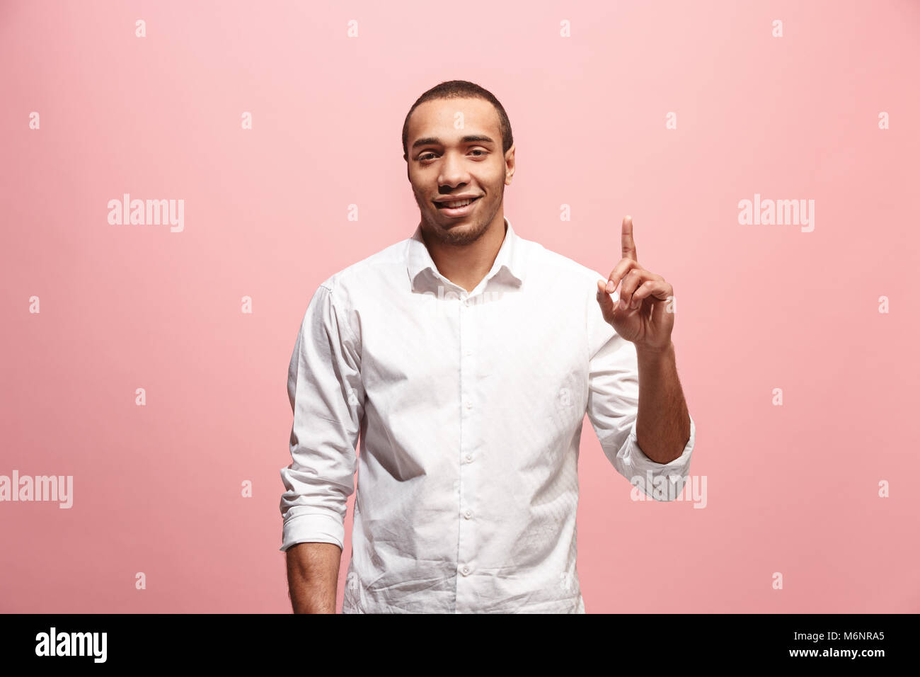 The happy business man point up, half length closeup portrait on pink ...