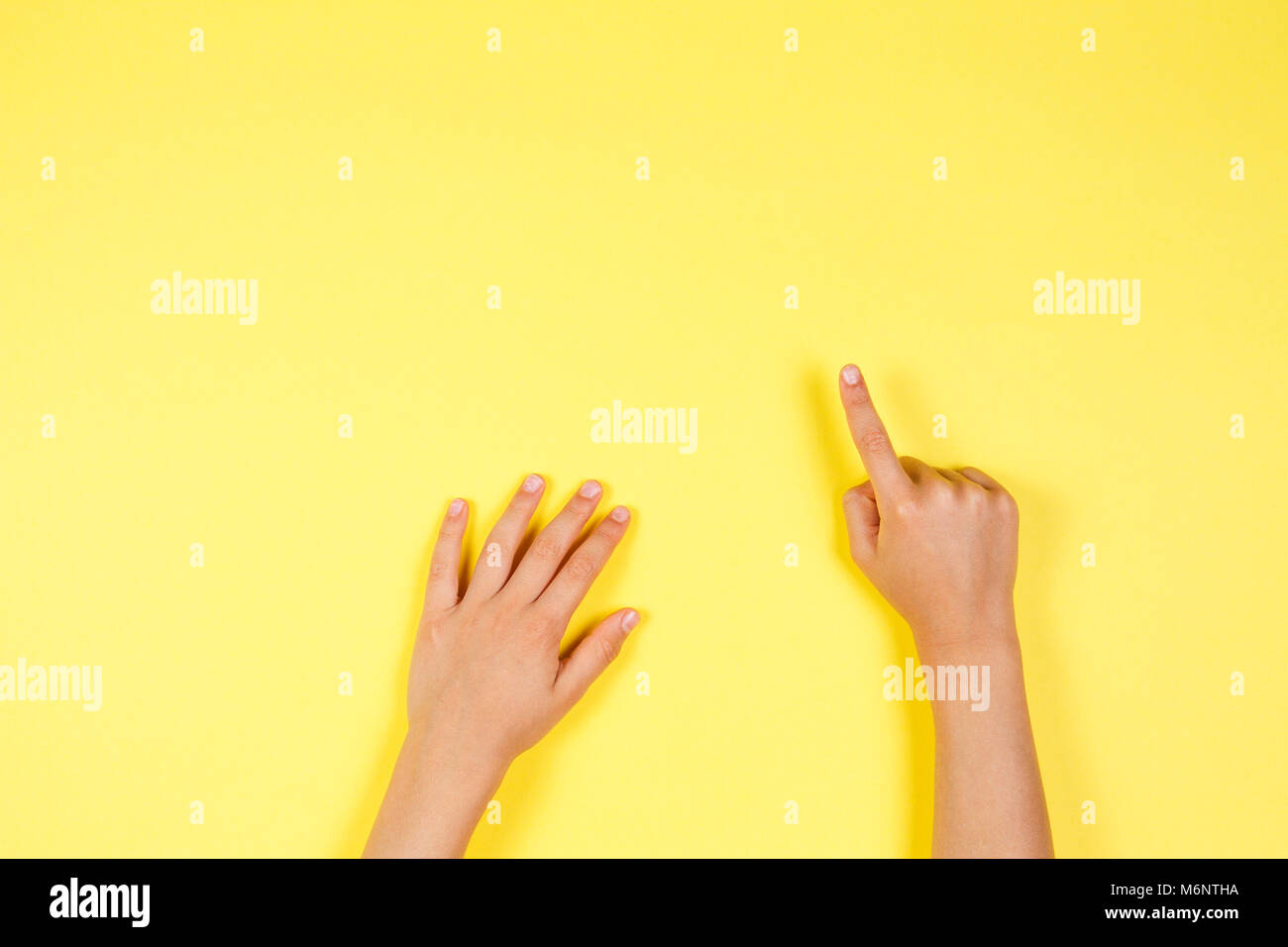 Children hands pointing on yellow background Stock Photo - Alamy