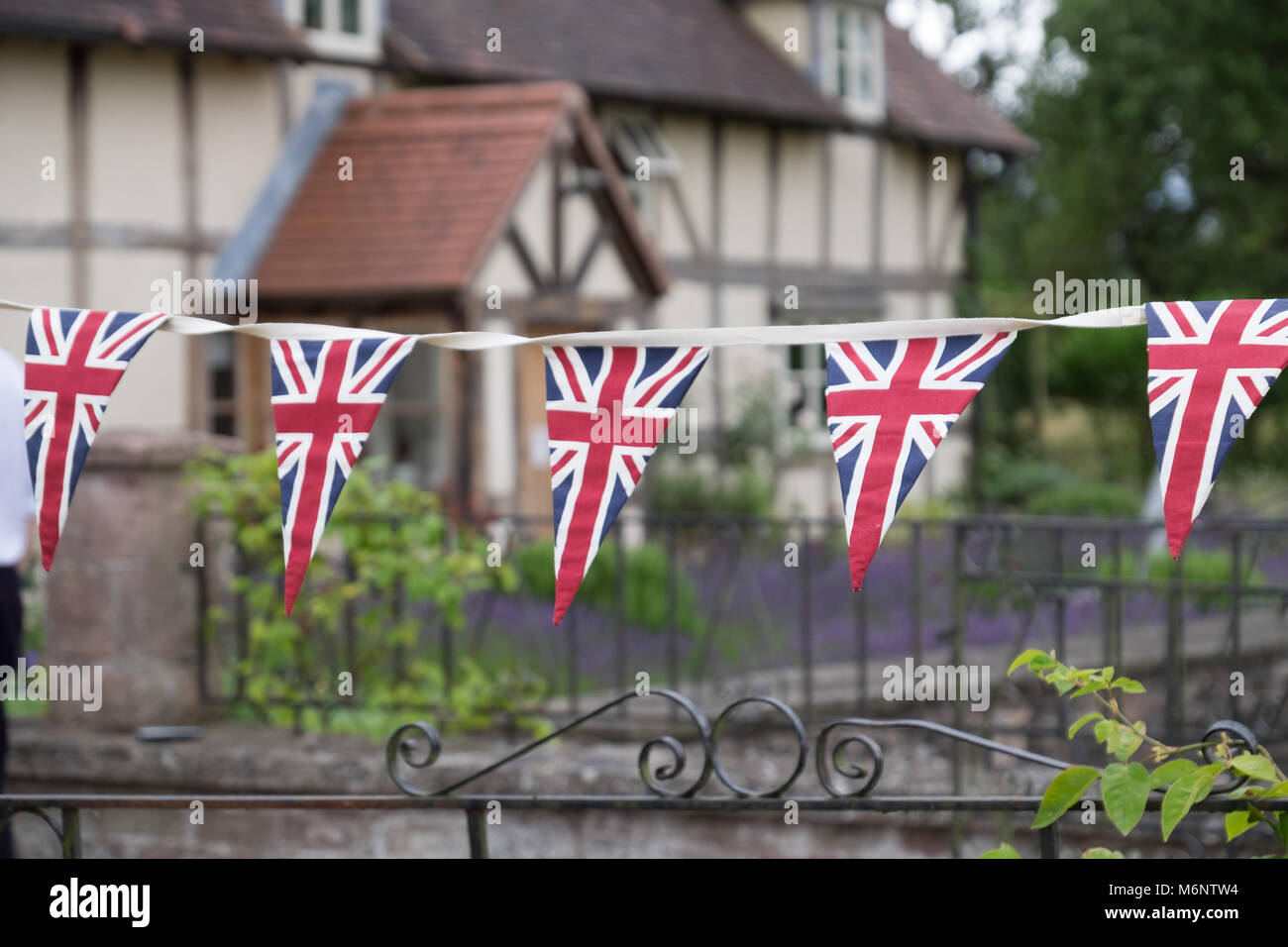Union Jack bunting outside traditional British house Stock Photo - Alamy