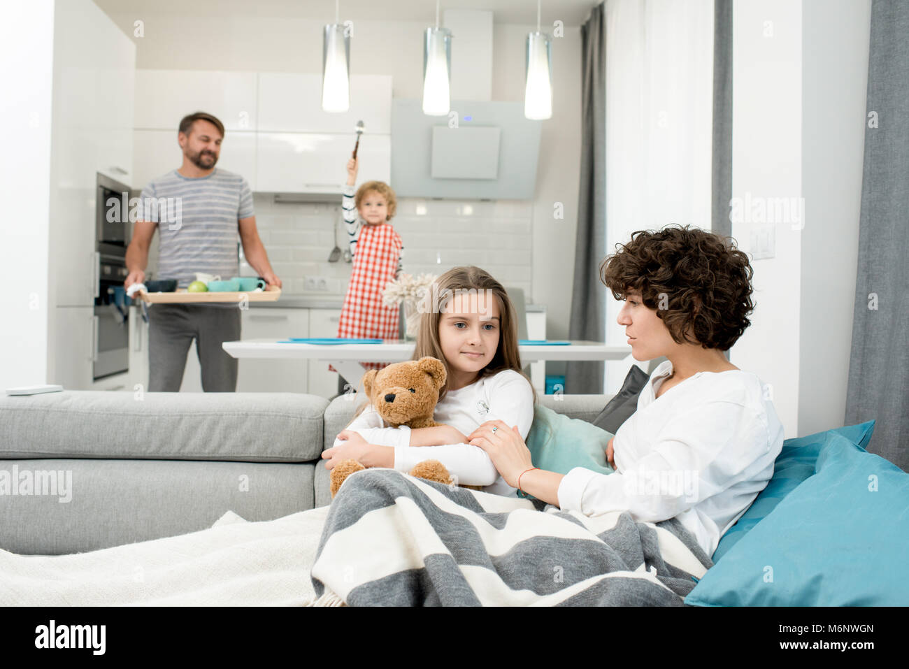 Portrait of happy young family with two children enjoying quiet weekend ...