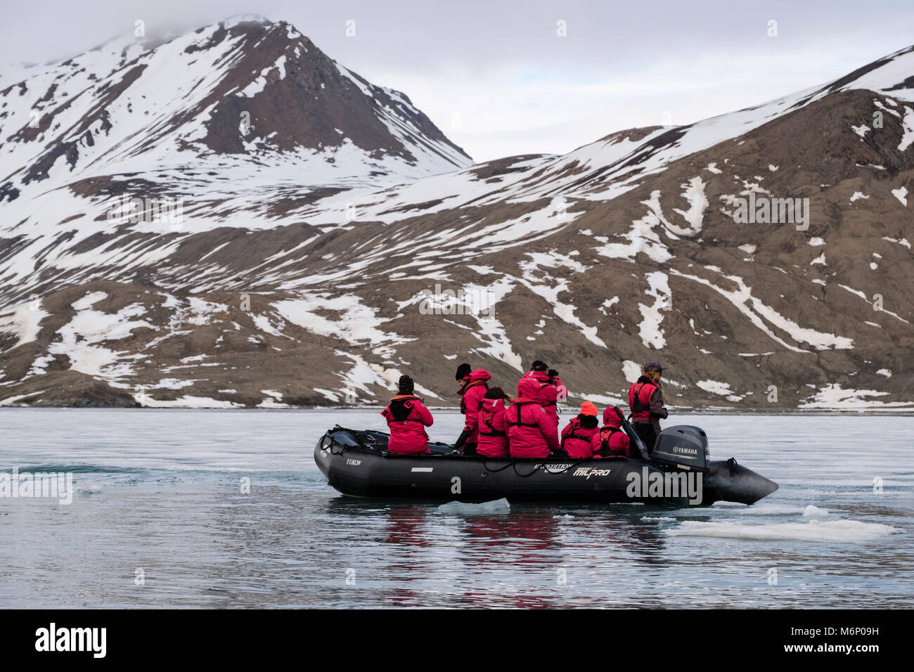 G Expedition cruise passengers in a Zodiac dinghy watching for wildlife ...