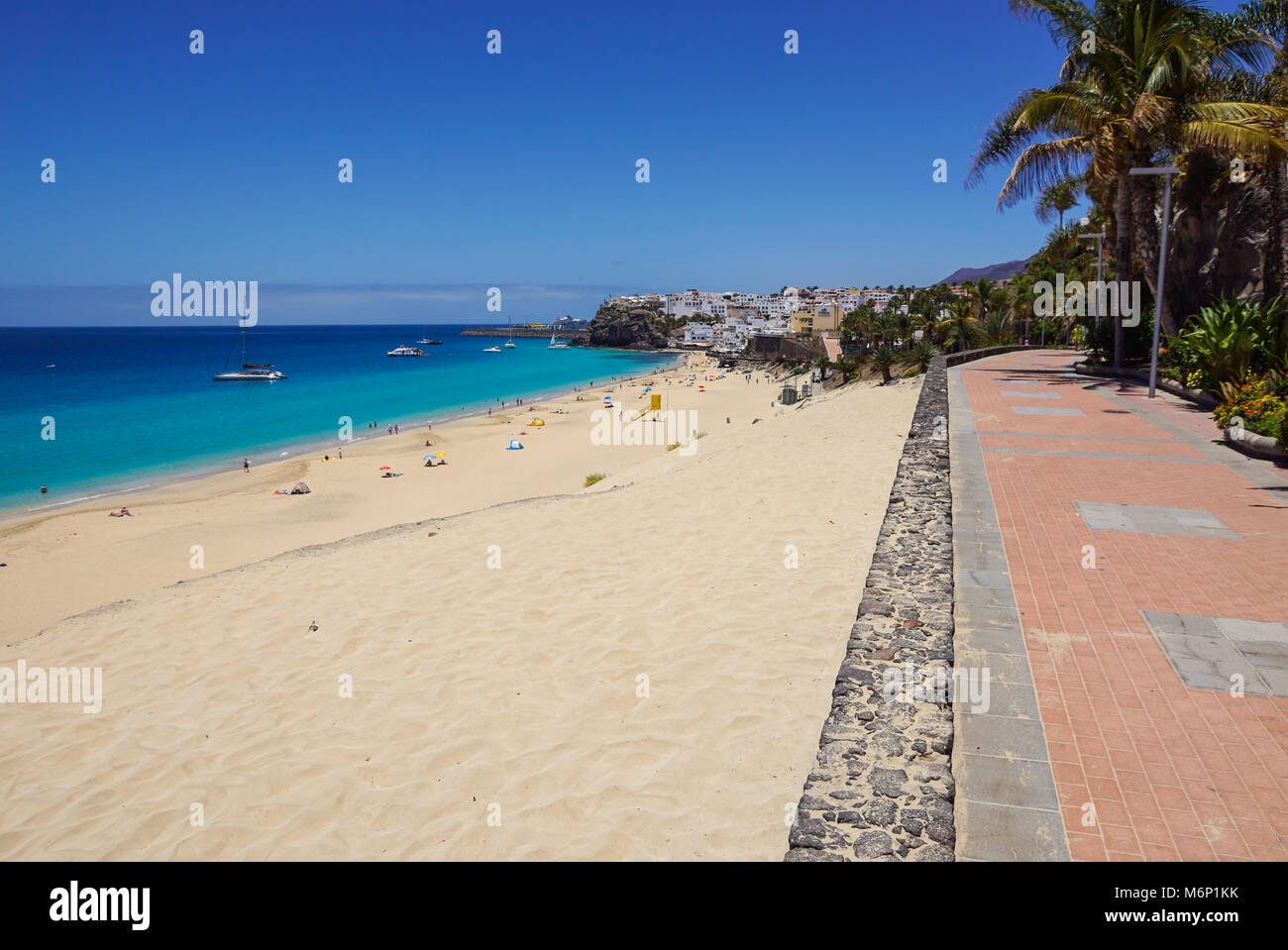 Promenade with tropical plants and flowers along a beach in Morro Jable ...