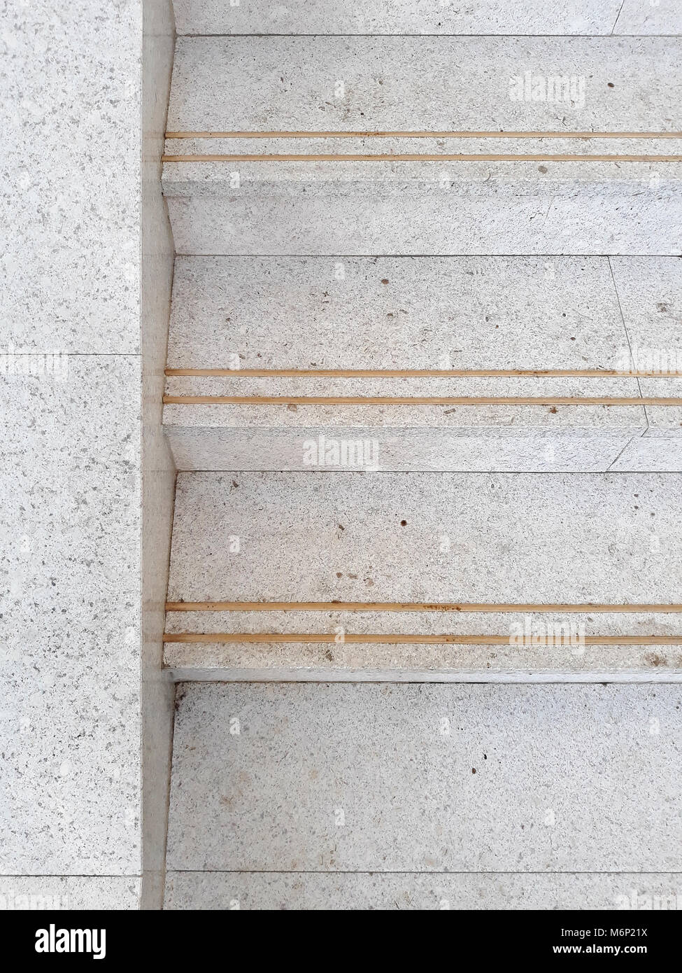 A fragment of a staircase made of marble steps with bronze inserts ...