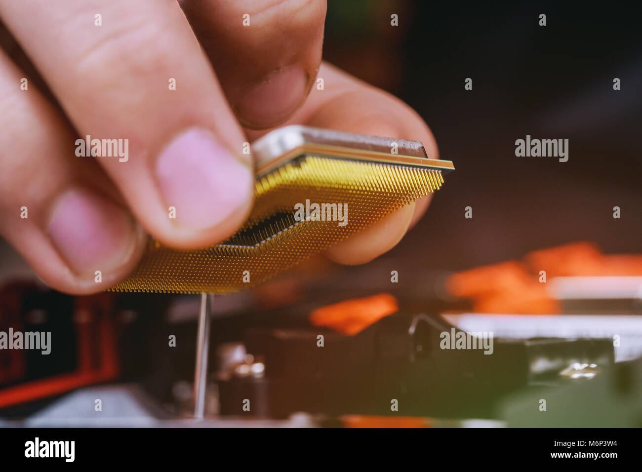 First person view hand holding a computer processor chip on motherboard ...