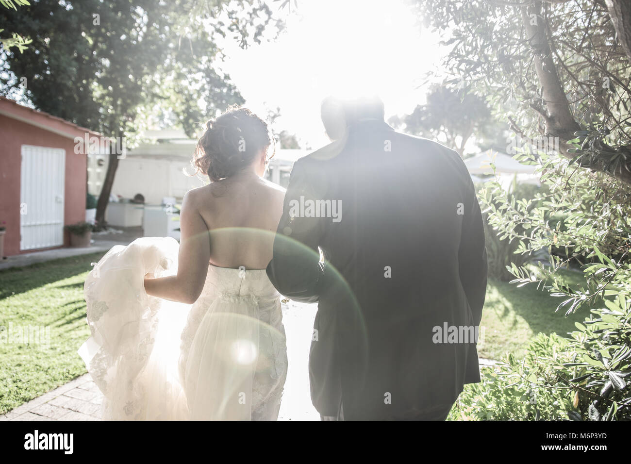 Bride and groom walking in a beautiful garden, with sunlight Stock ...