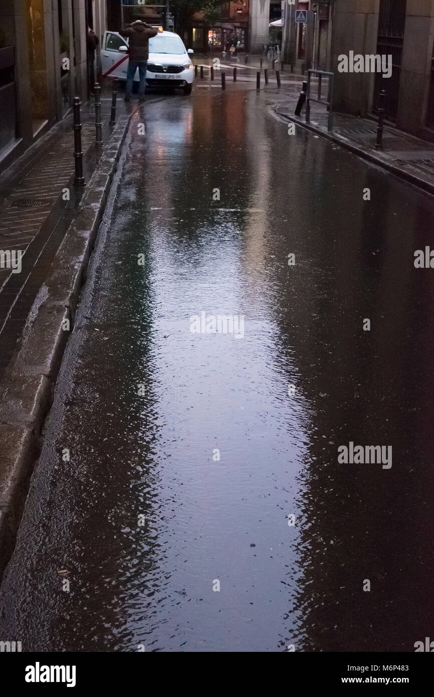 A reflection of light on a wet street in Madrid during a rainy day ...