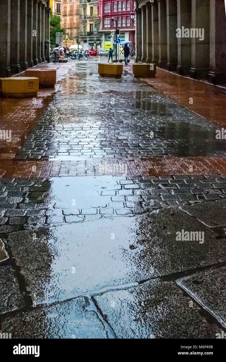 A reflection of light on a wet street in Madrid during a rainy day ...
