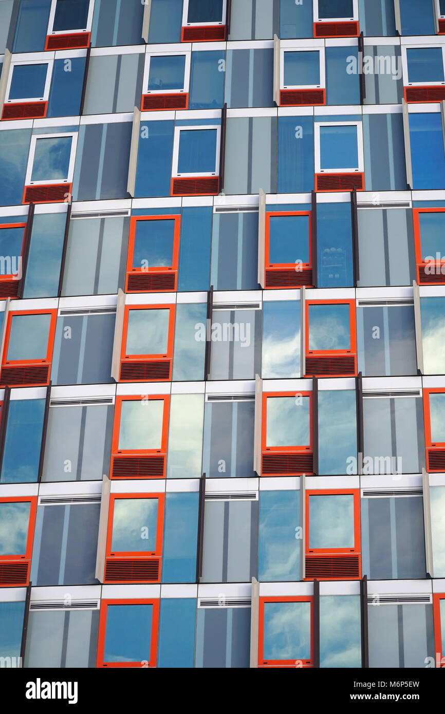 Red outline window pattern with reflecting windows of a cloudy blue sky ...