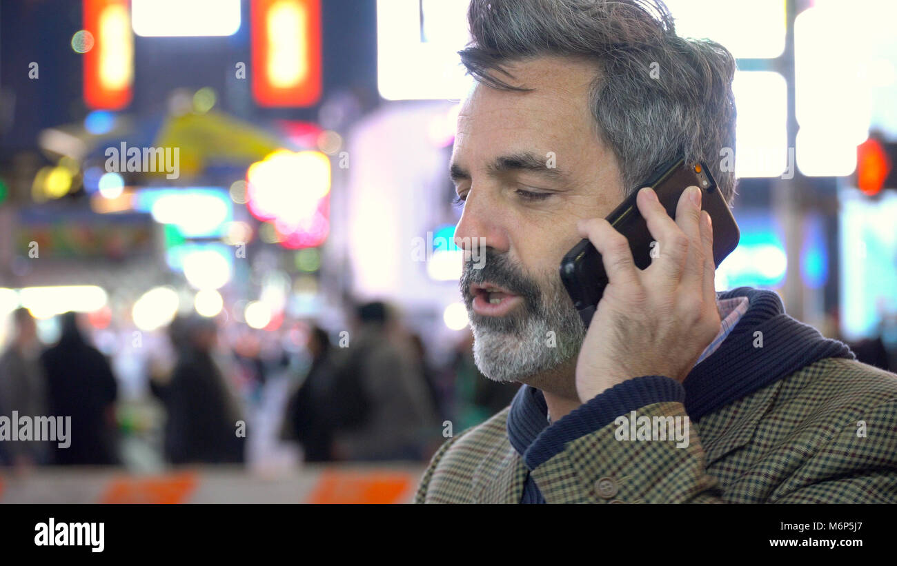 Traveling businessman using his smart cell phone talk to clients ...