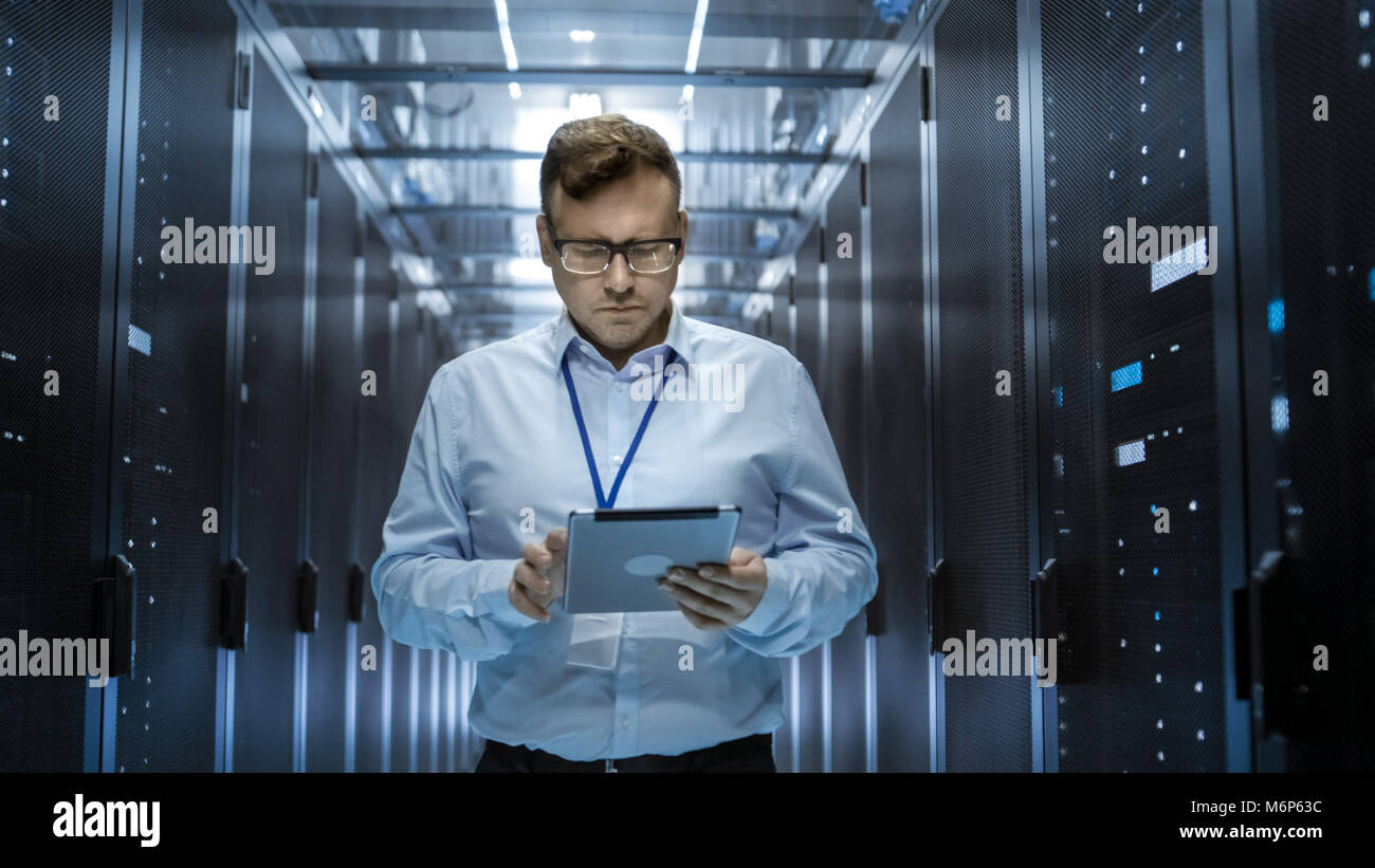 IT Technician Walks Through Rows of Server Racks in Data Center ...